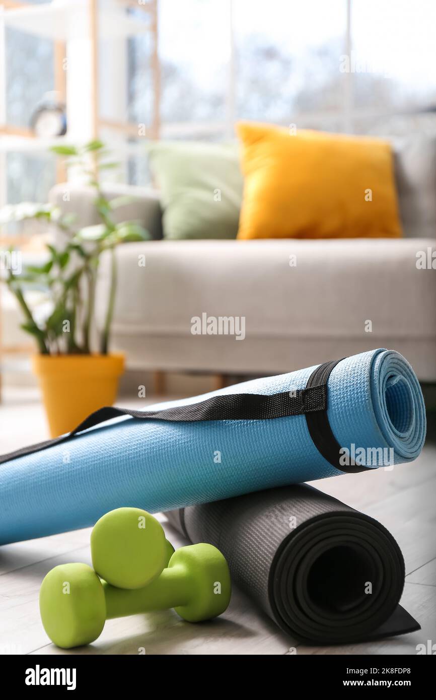 Yoga mats and dumbbells in light room Stock Photo - Alamy