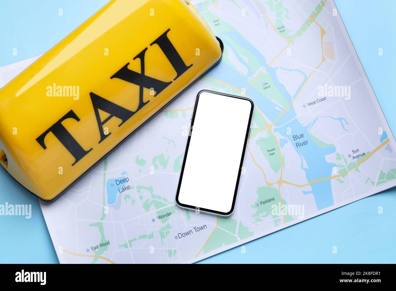 Yellow taxi roof sign, map and mobile phone on blue background Stock ...