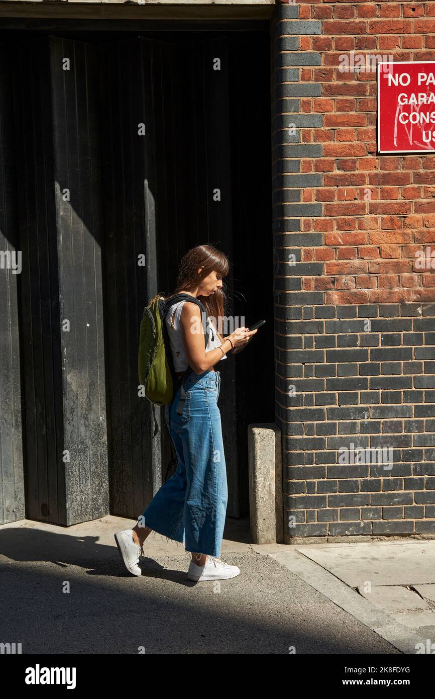 Woman mobile phone walking england hi-res stock photography and images ...
