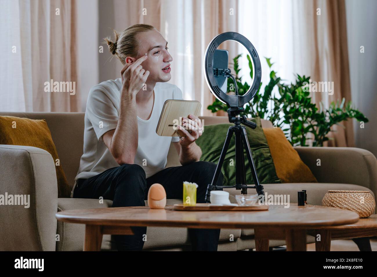 Happy young influencer vlogging through mobile phone at home Stock ...