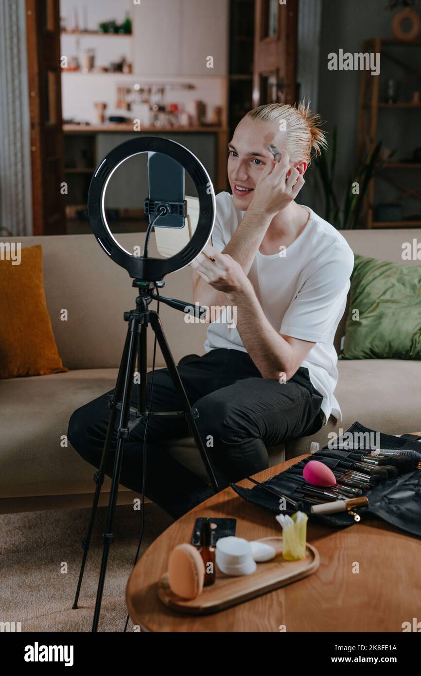 Influencer vlogging make-up tutorial through smart phone at home Stock ...