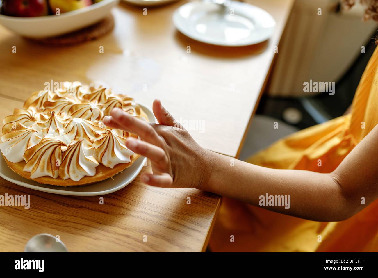 Hand of girl touching meringue pie on table Stock Photo - Alamy