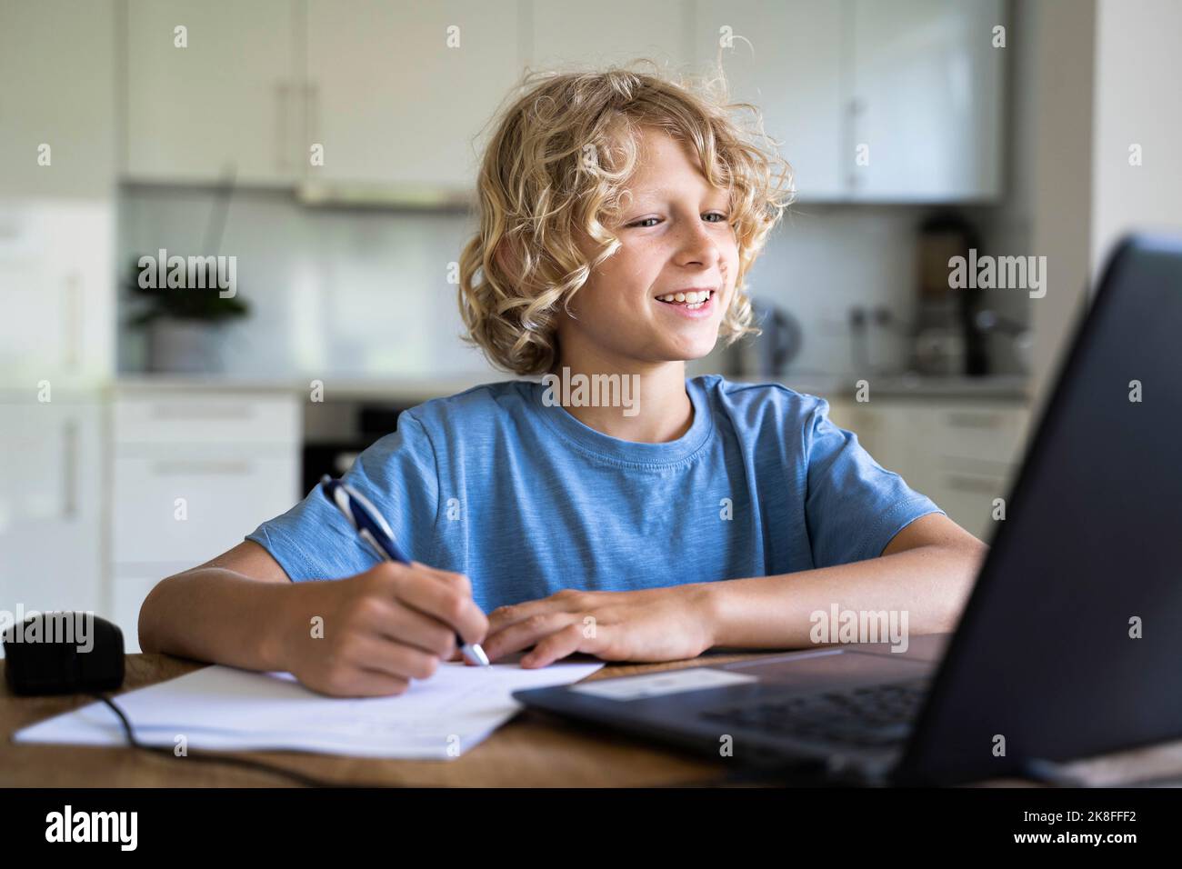 Smiling boy doing homework hi-res stock photography and images - Alamy