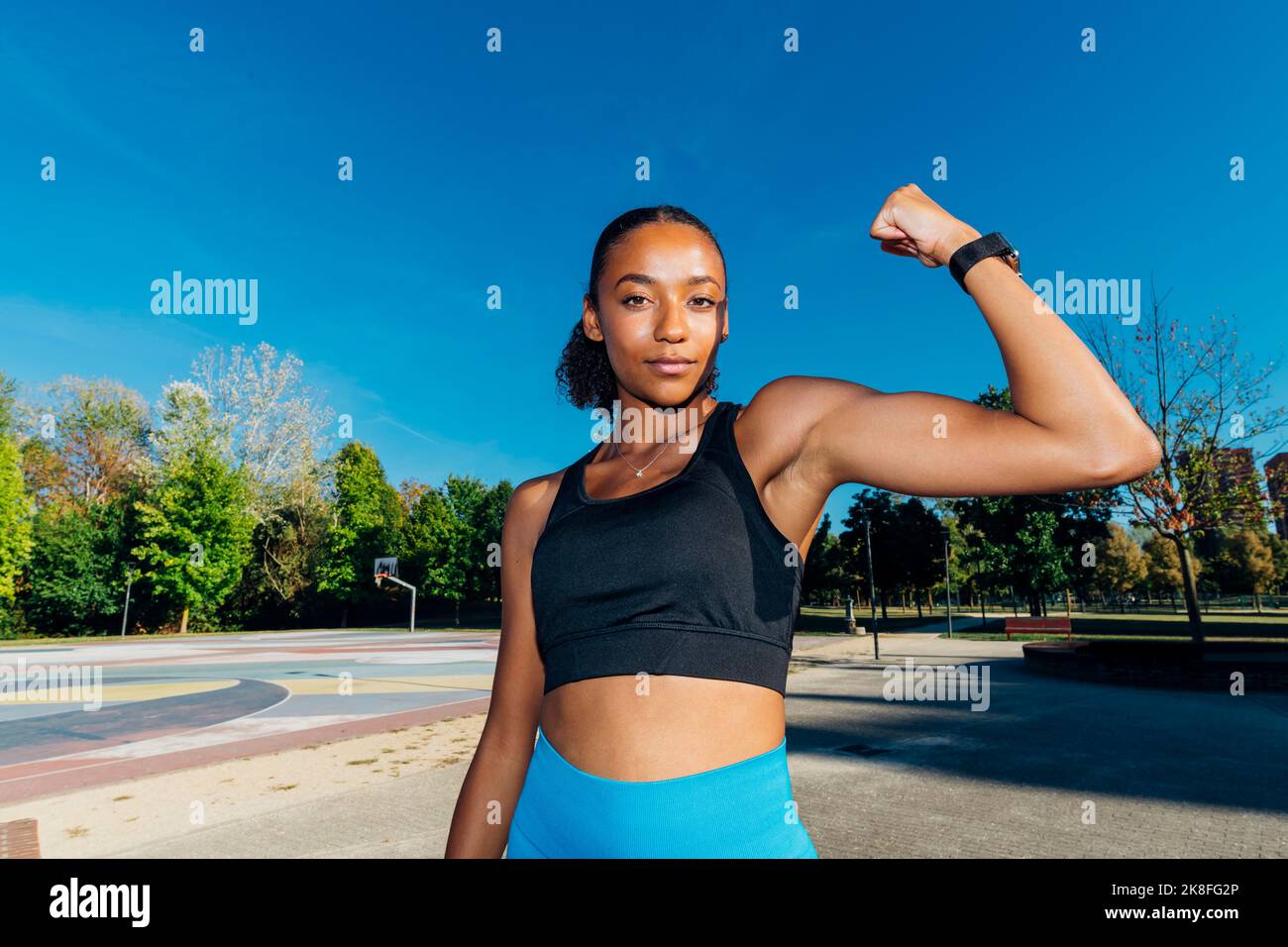 Young athlete flexing bicep in basketball court Stock Photo - Alamy