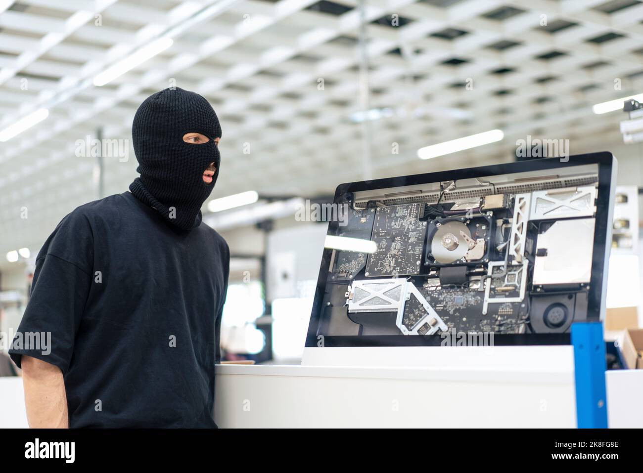 Robber standing by computer at warehouse Stock Photo - Alamy