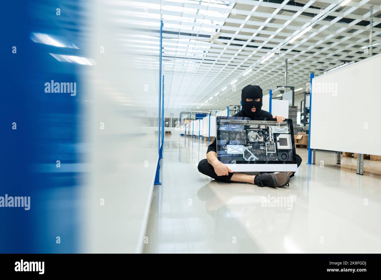 Thief with desktop PC sitting on floor at warehouse Stock Photo - Alamy