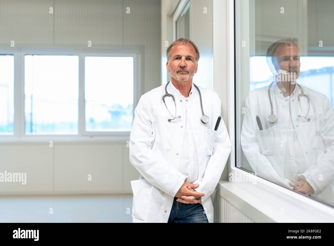 Senior male doctor standing glass hi-res stock photography and images ...