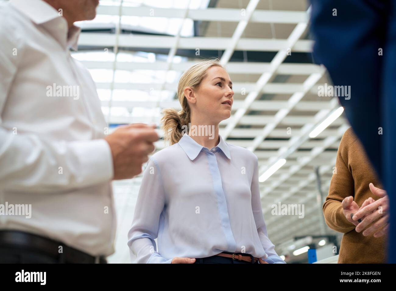 Blond businesswoman discussing with colleagues Stock Photo - Alamy