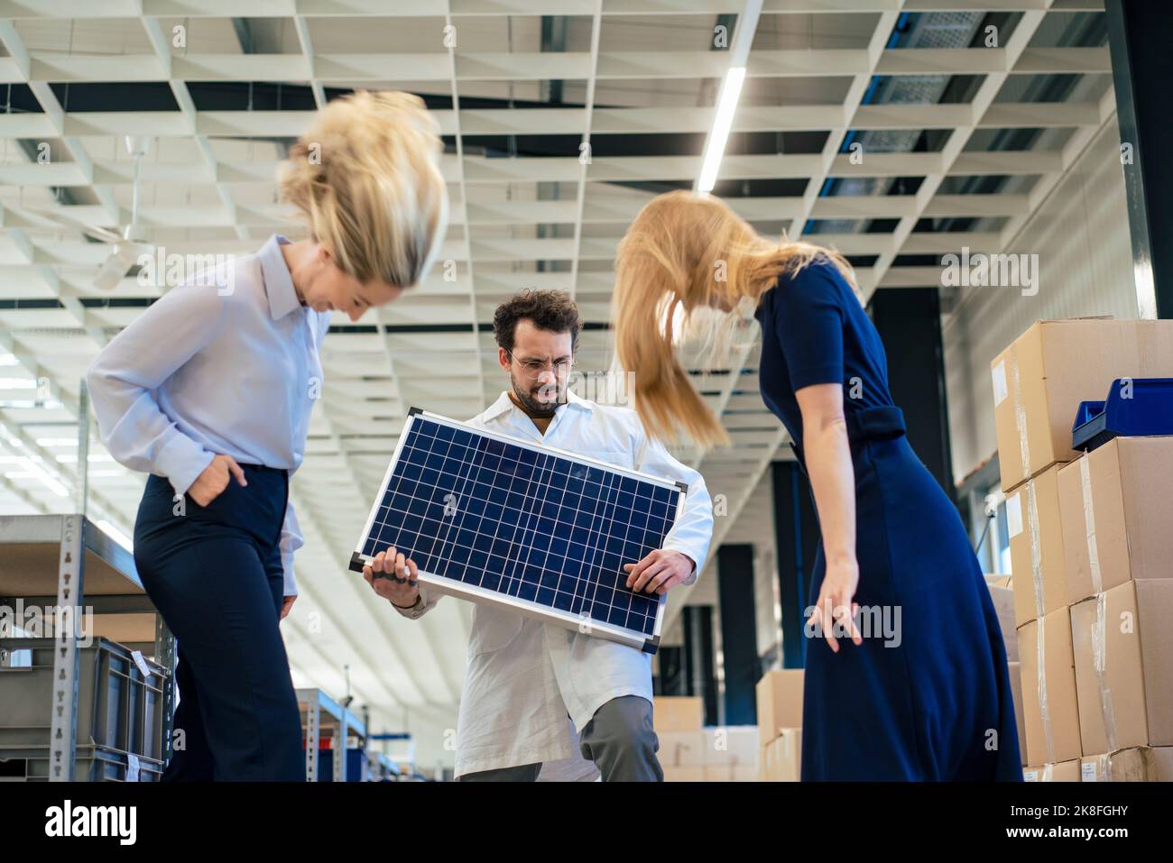 Carefree engineer playing air guitar with solar panel by colleagues in ...