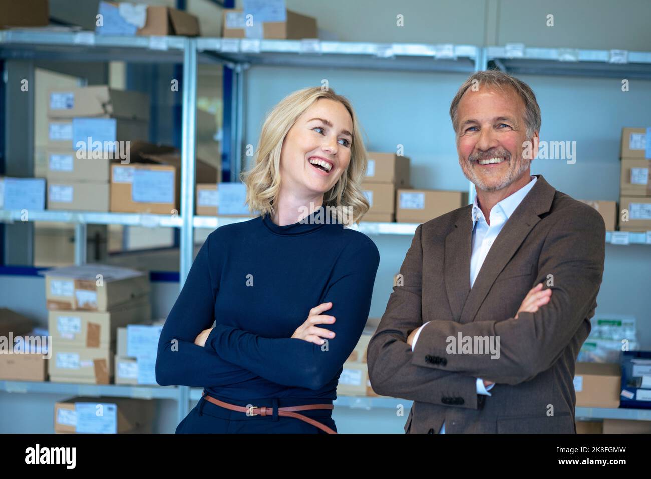 Happy business colleagues standing together with arms crossed in front ...