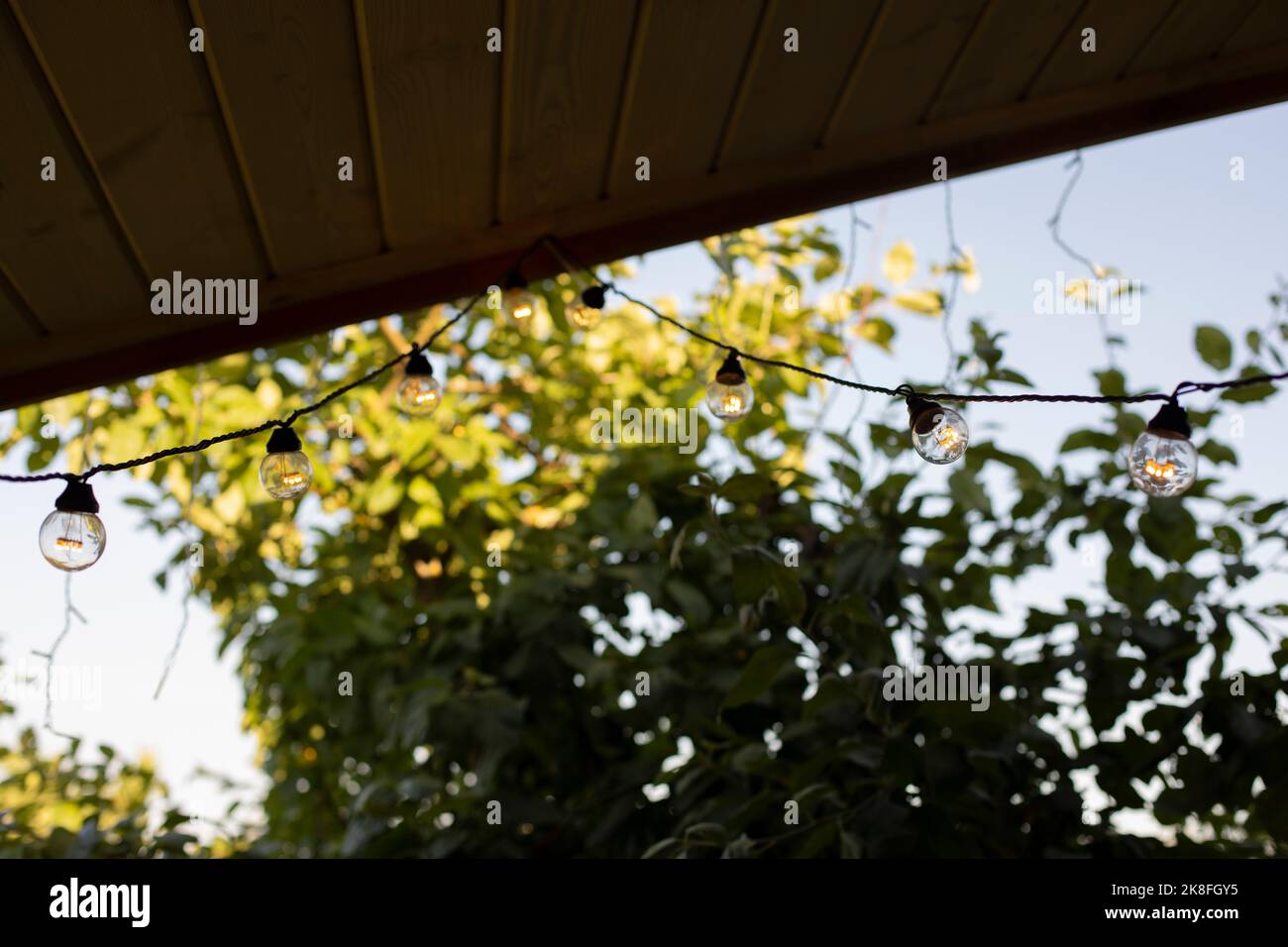 Light bulbs on roof of veranda. Exterior details. Garland on edge of ...
