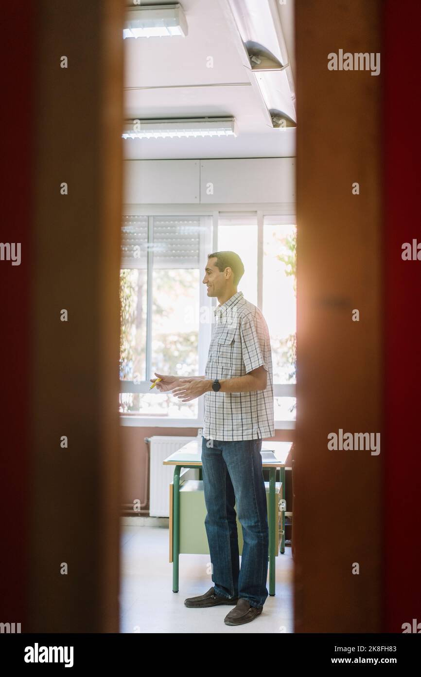 Professor teaching in classroom seen through doorway Stock Photo - Alamy