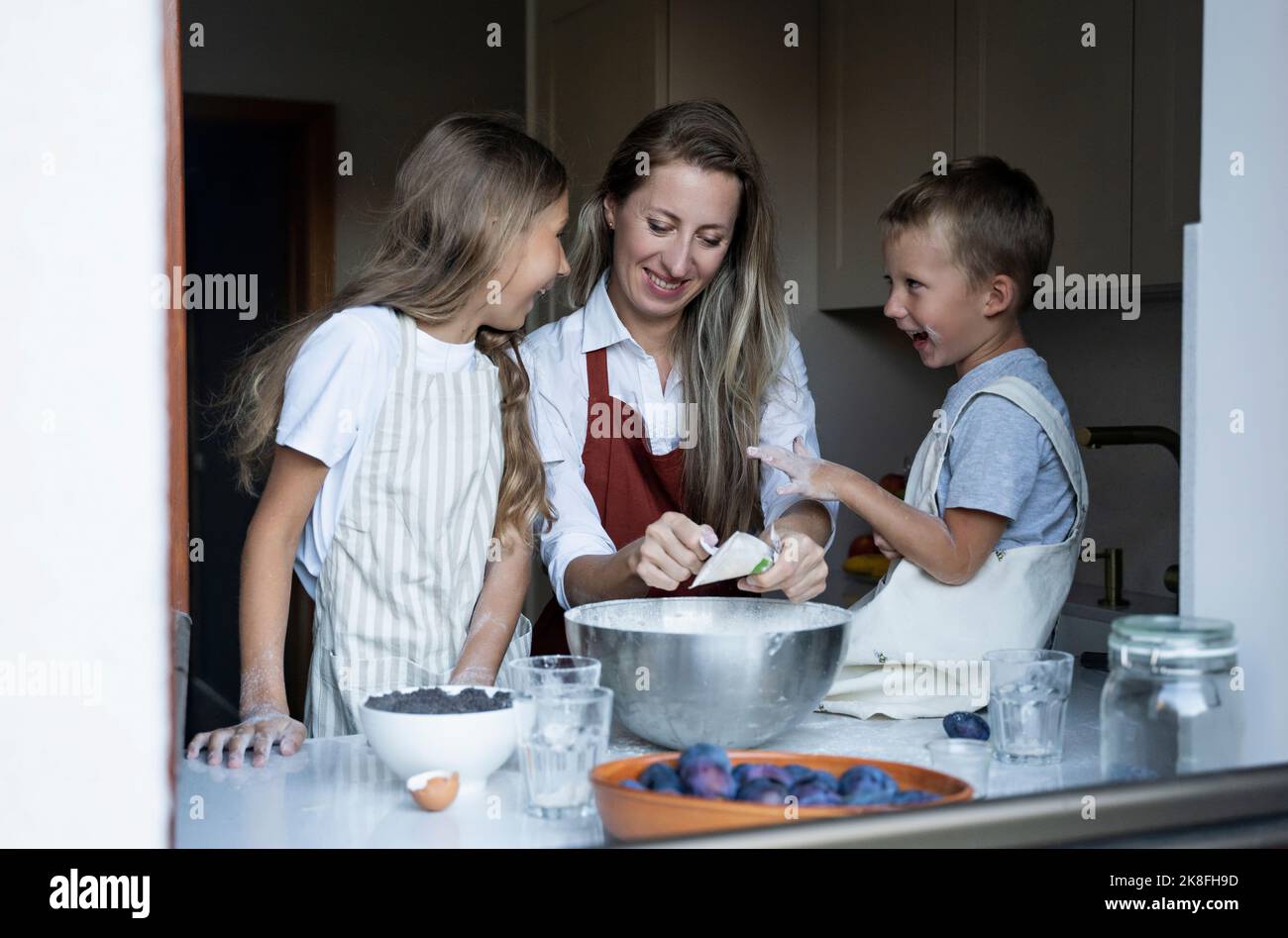 Cheerful children helping mother cooking at home Stock Photo - Alamy