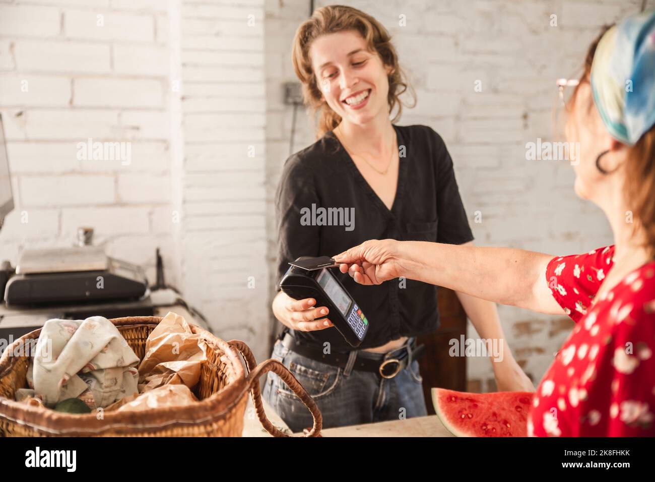 Customer paying with credit card at checkout counter in greengrocer ...