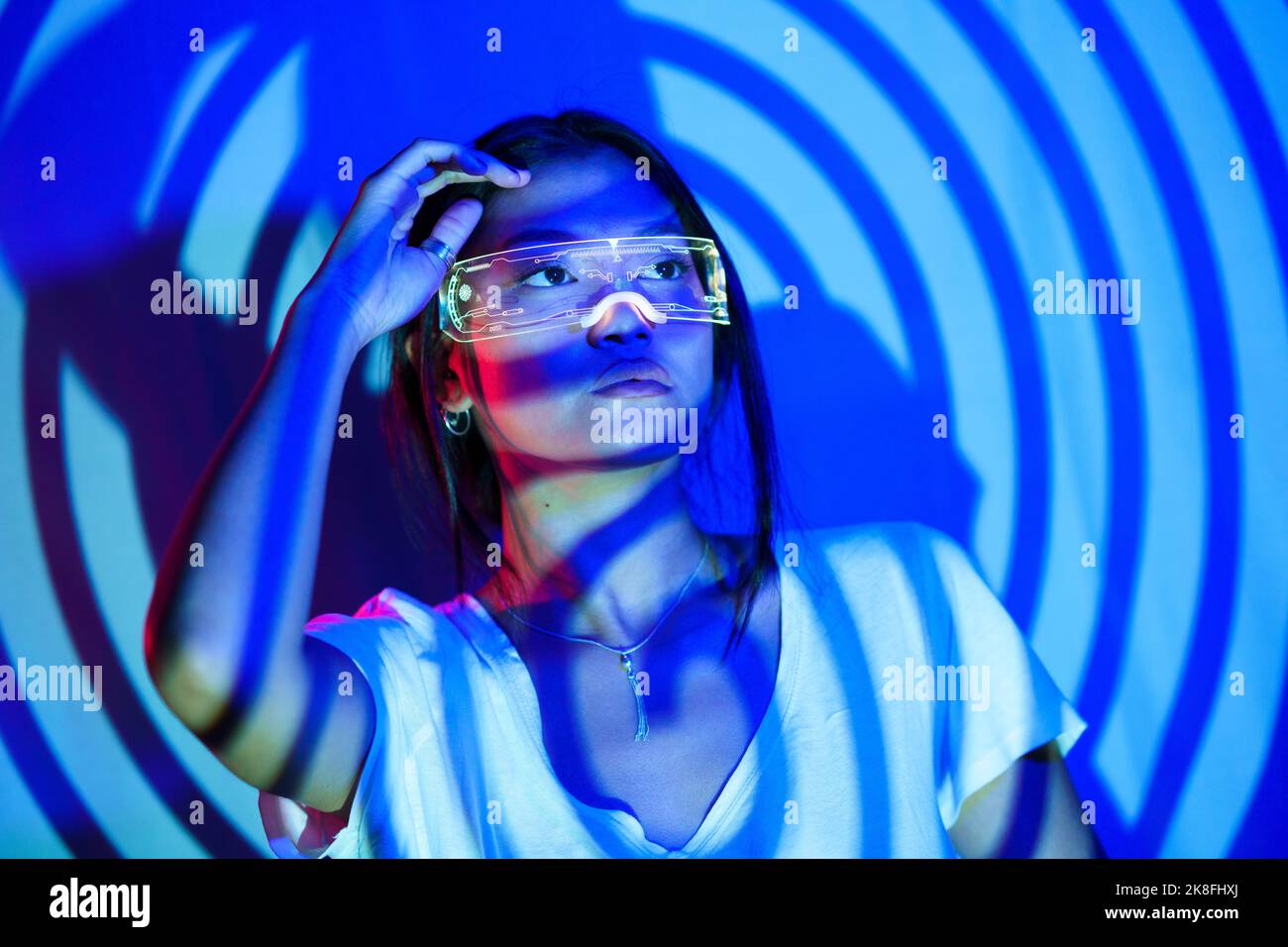 Thoughtful woman in smart glasses under spiral shadow Stock Photo - Alamy