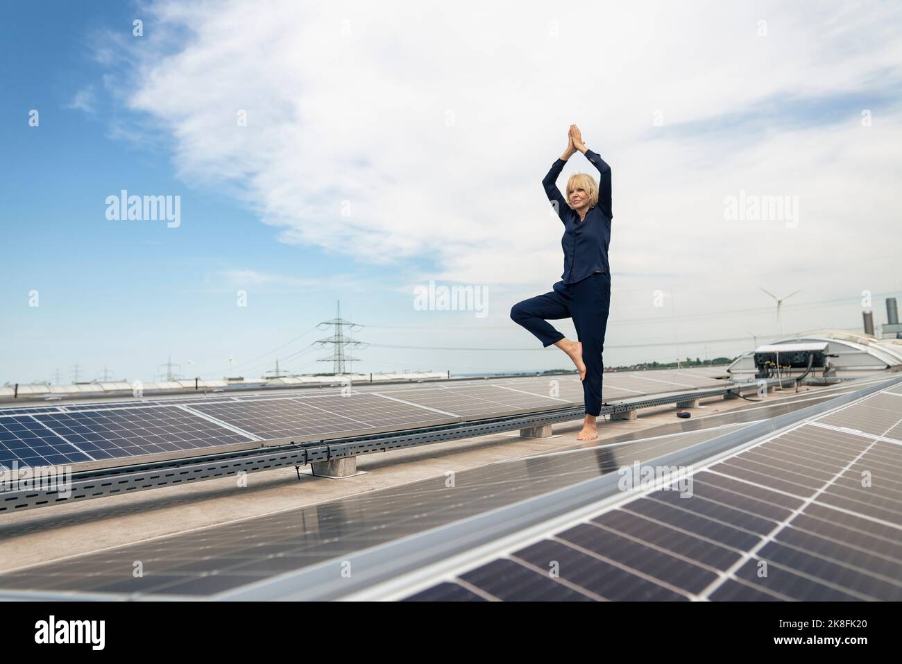 Senior businesswoman doing yoga at solar power station Stock Photo - Alamy