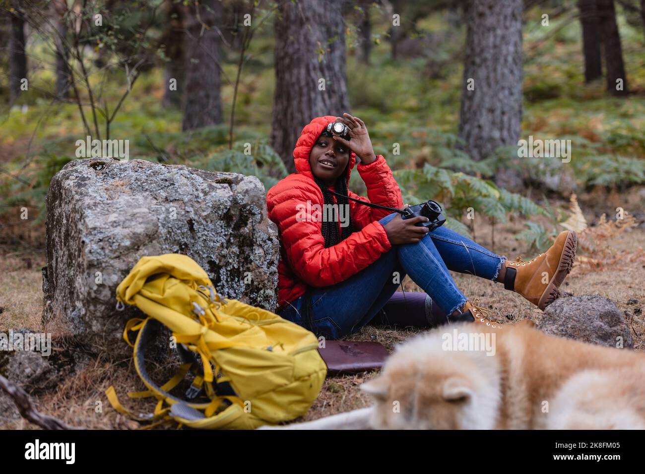 Woman wearing flashlight sitting with camera in forest Stock Photo - Alamy
