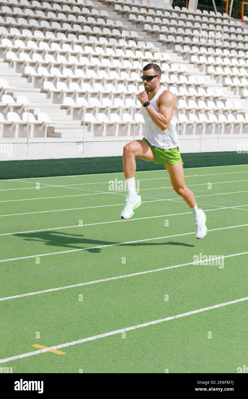 Active man practicing running on sports track Stock Photo - Alamy