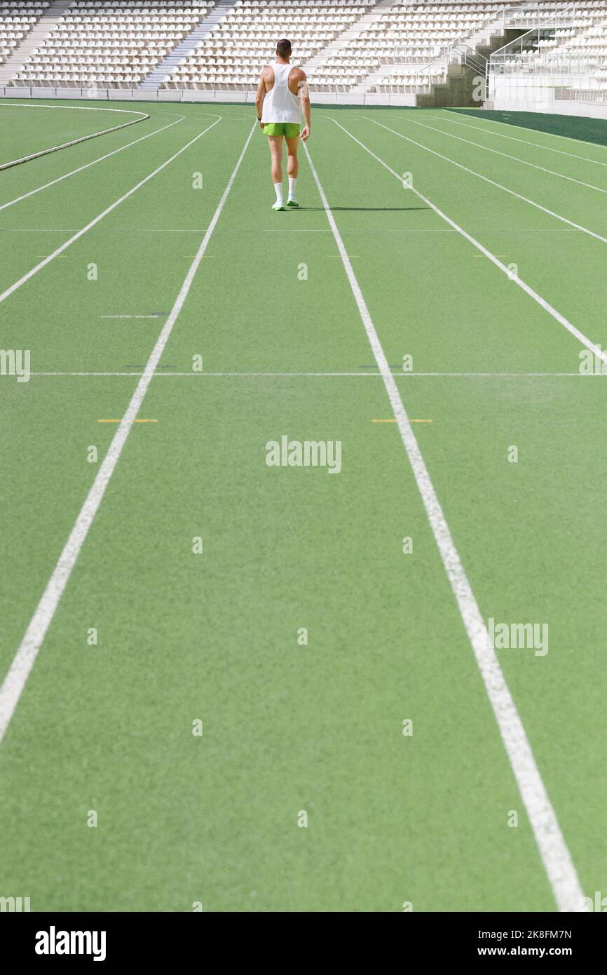 Sportsman walking on running track at sports field Stock Photo - Alamy
