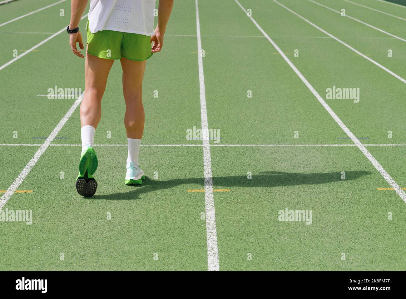Athlete walking on running track on sunny day Stock Photo - Alamy