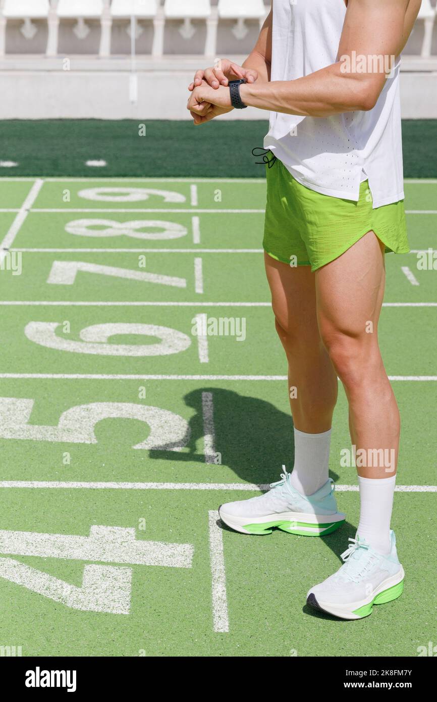 Athlete wearing smart watch on running track Stock Photo - Alamy