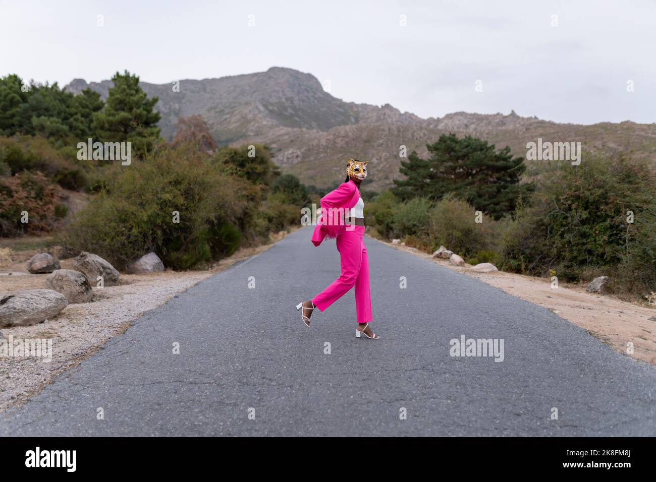 Woman wearing tiger mask standing on road in front of mountain Stock ...