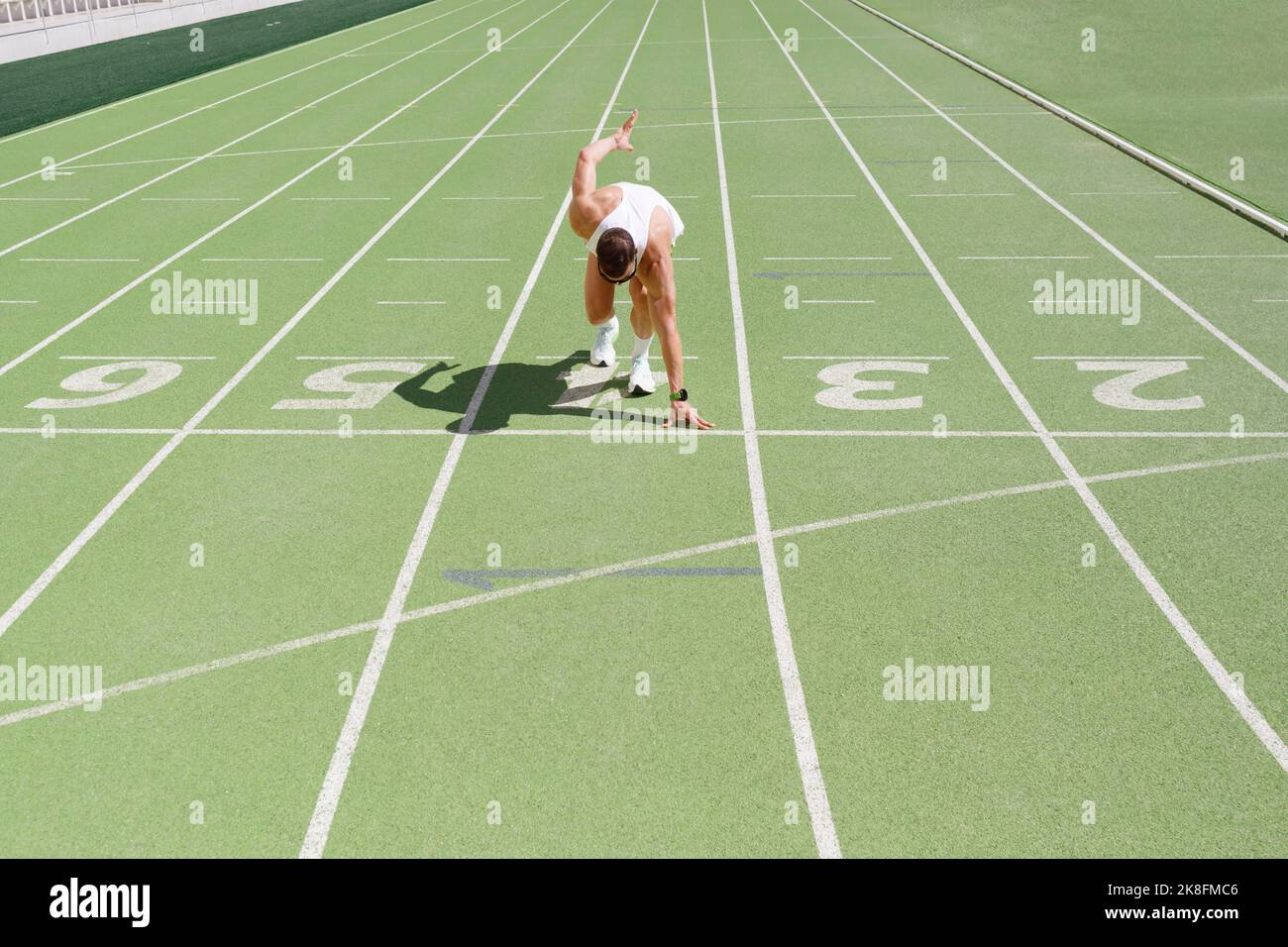 Athlete getting ready to start running on track Stock Photo - Alamy