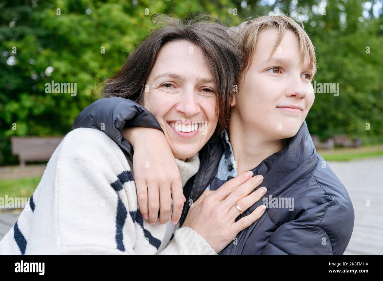 Son arm around of mother in park Stock Photo - Alamy