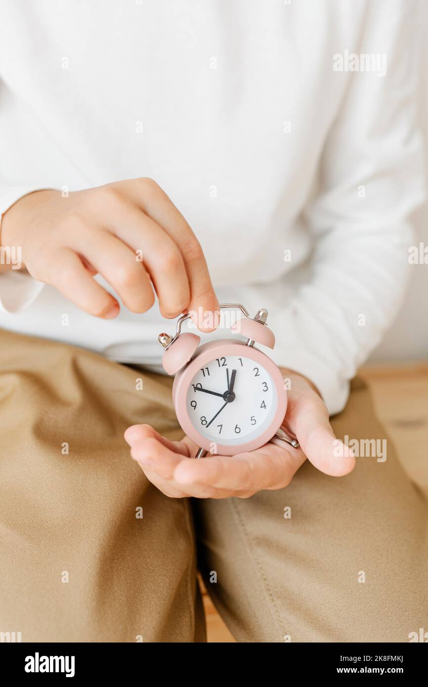 Hands of girl holding pink alarm clock Stock Photo - Alamy