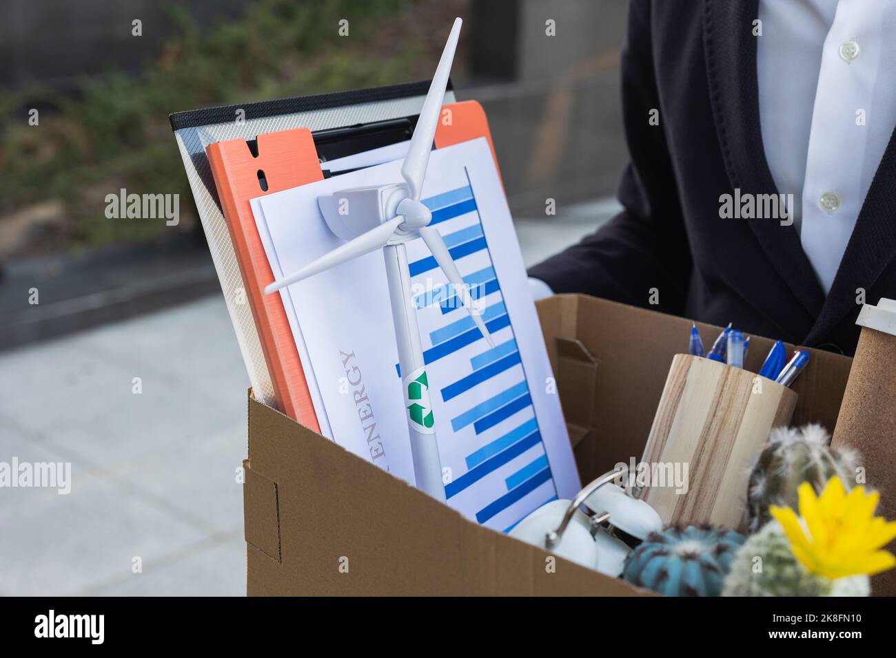 Businessman holding box with wind turbine model and documents Stock ...