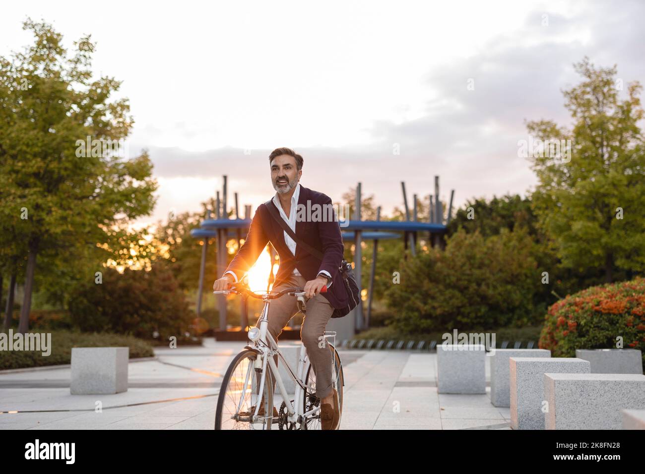 Happy commuter riding bicycle on footpath Stock Photo - Alamy