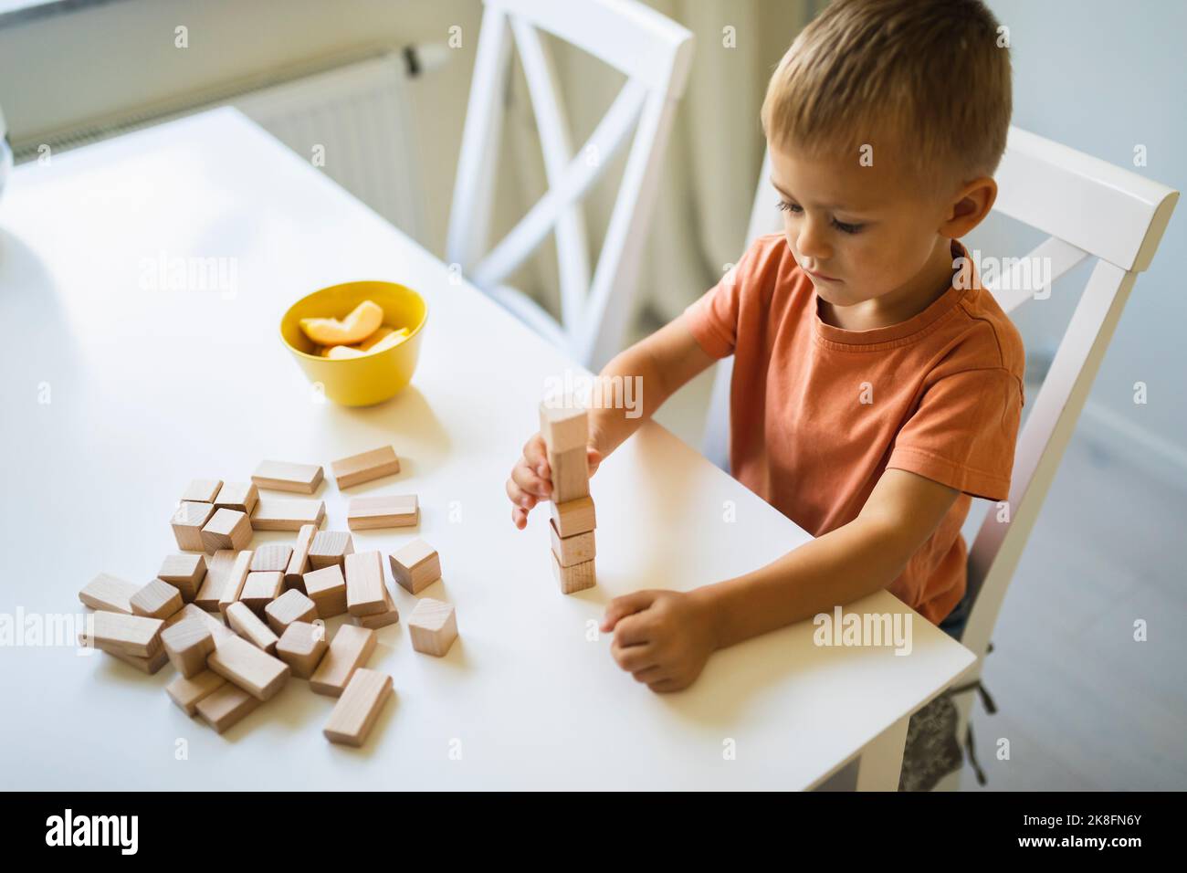 Boy stacking toy blocks on dining table at home Stock Photo - Alamy