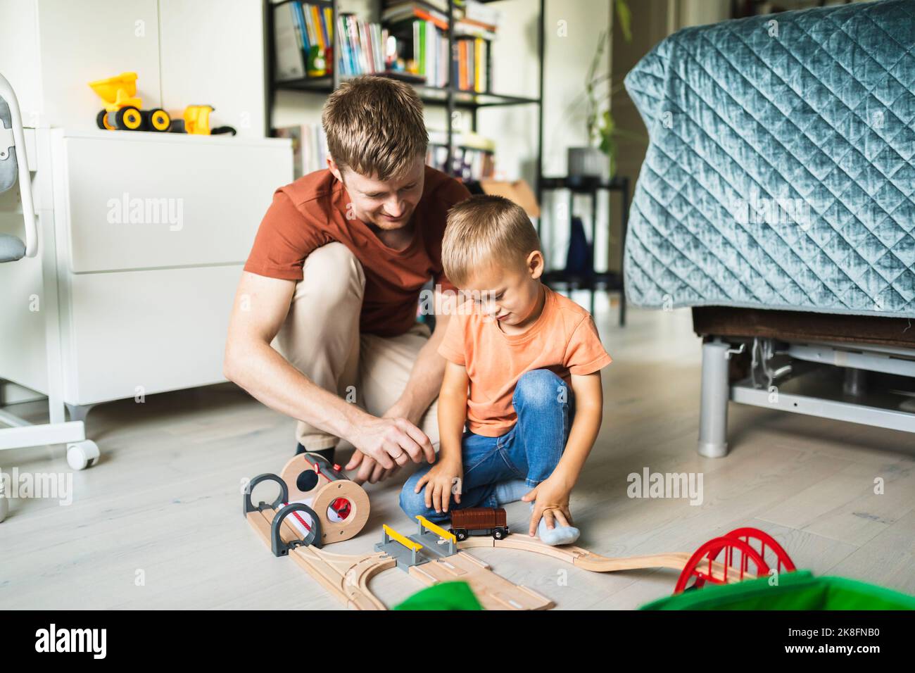 Father and son playing together with miniature train at home Stock ...