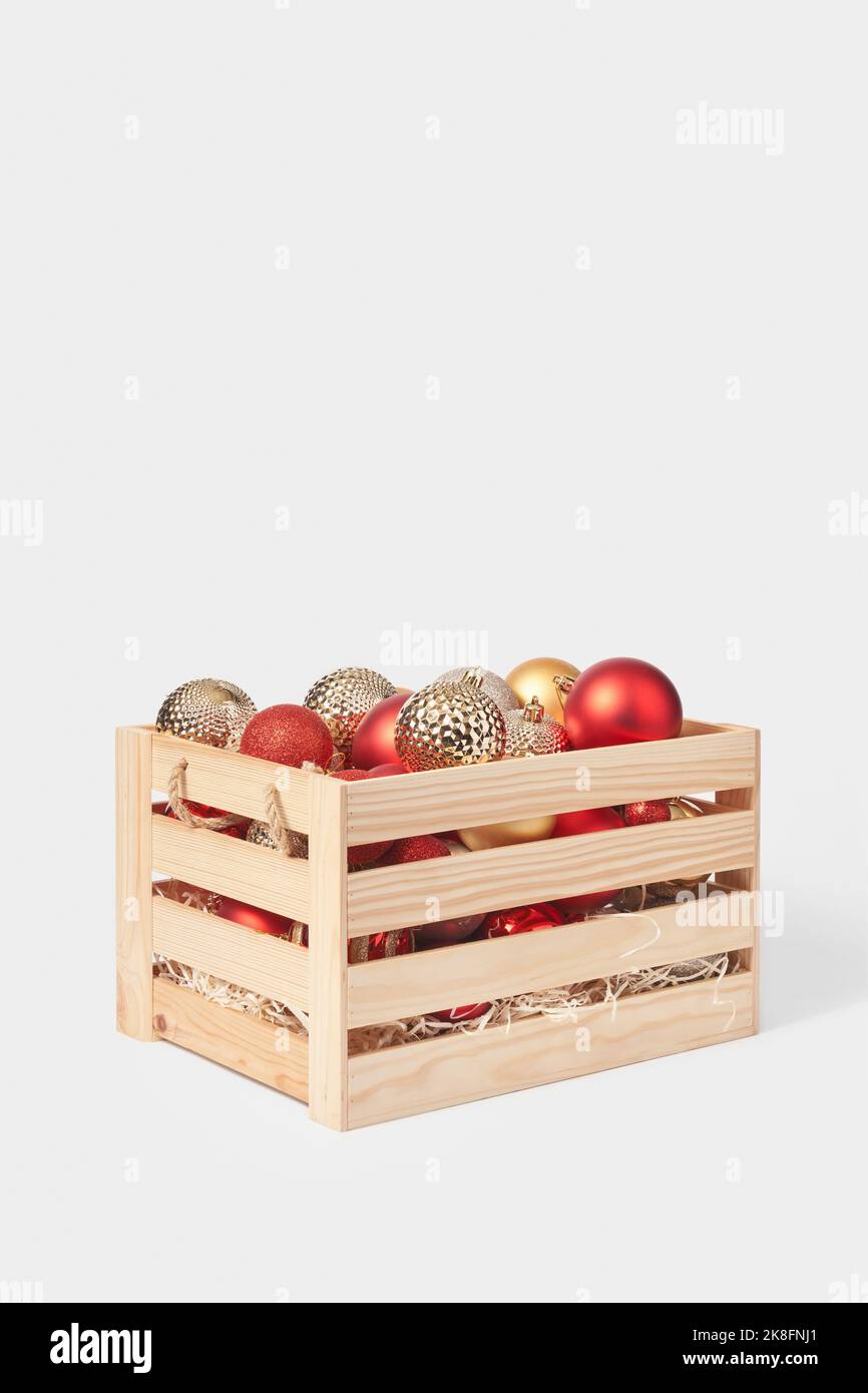 Wooden box full of colorful christmas baubles against white background ...