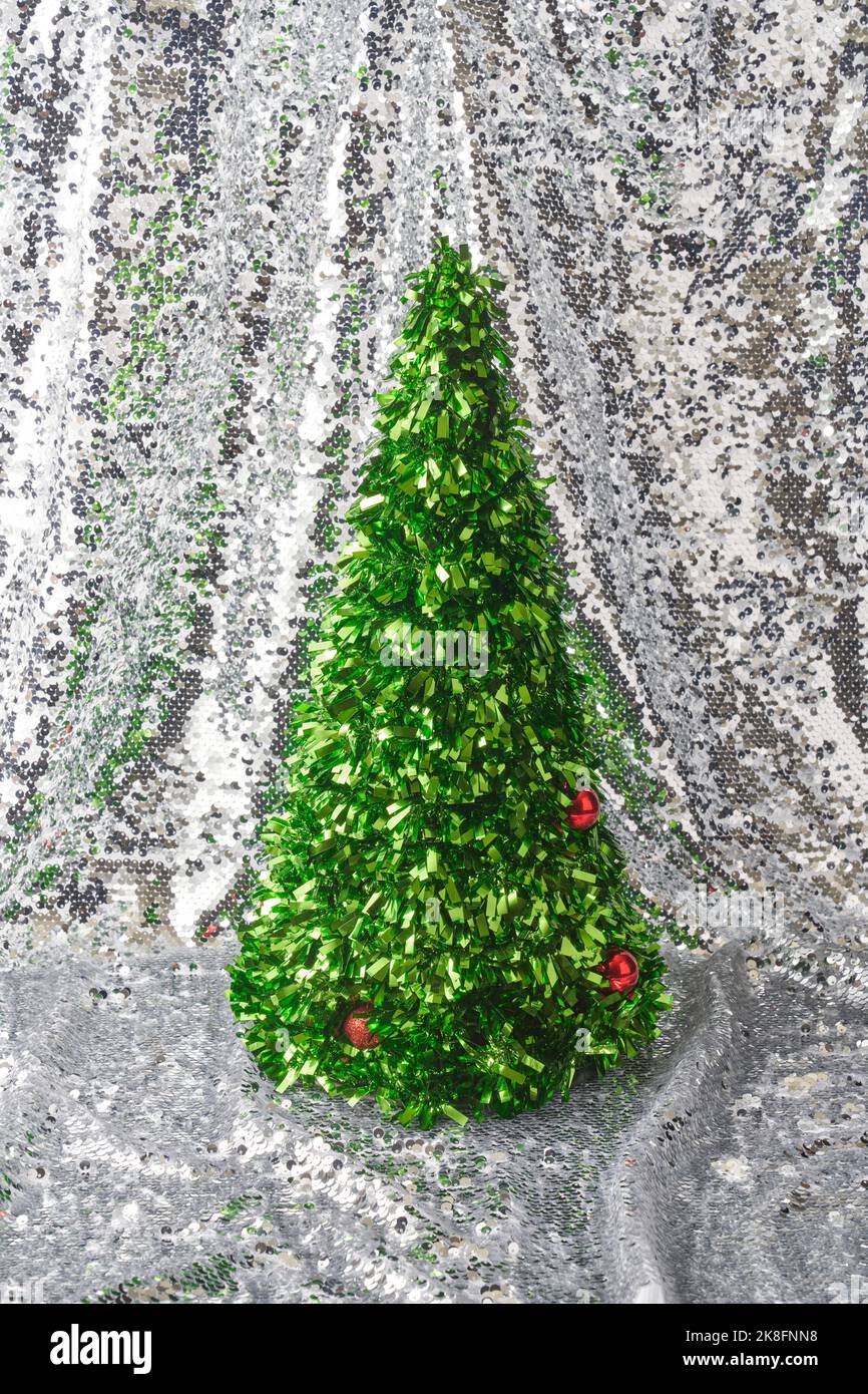 Decorated confetti Christmas tree against shiny silver sequins Stock ...