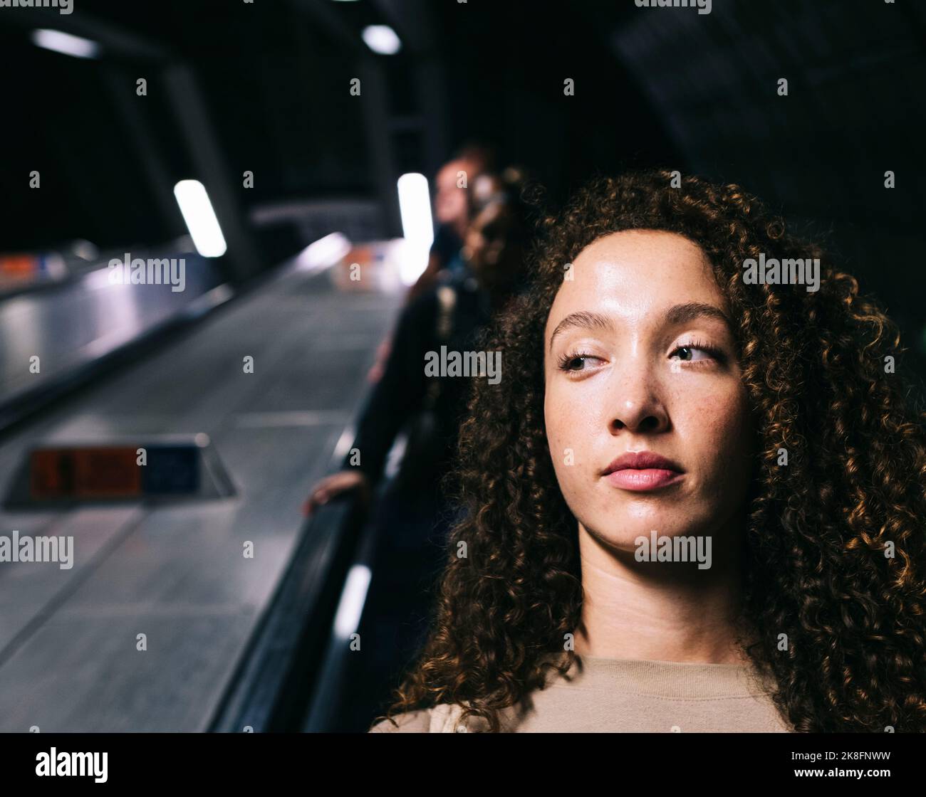 Young woman moving down on escalator in underground station Stock Photo ...