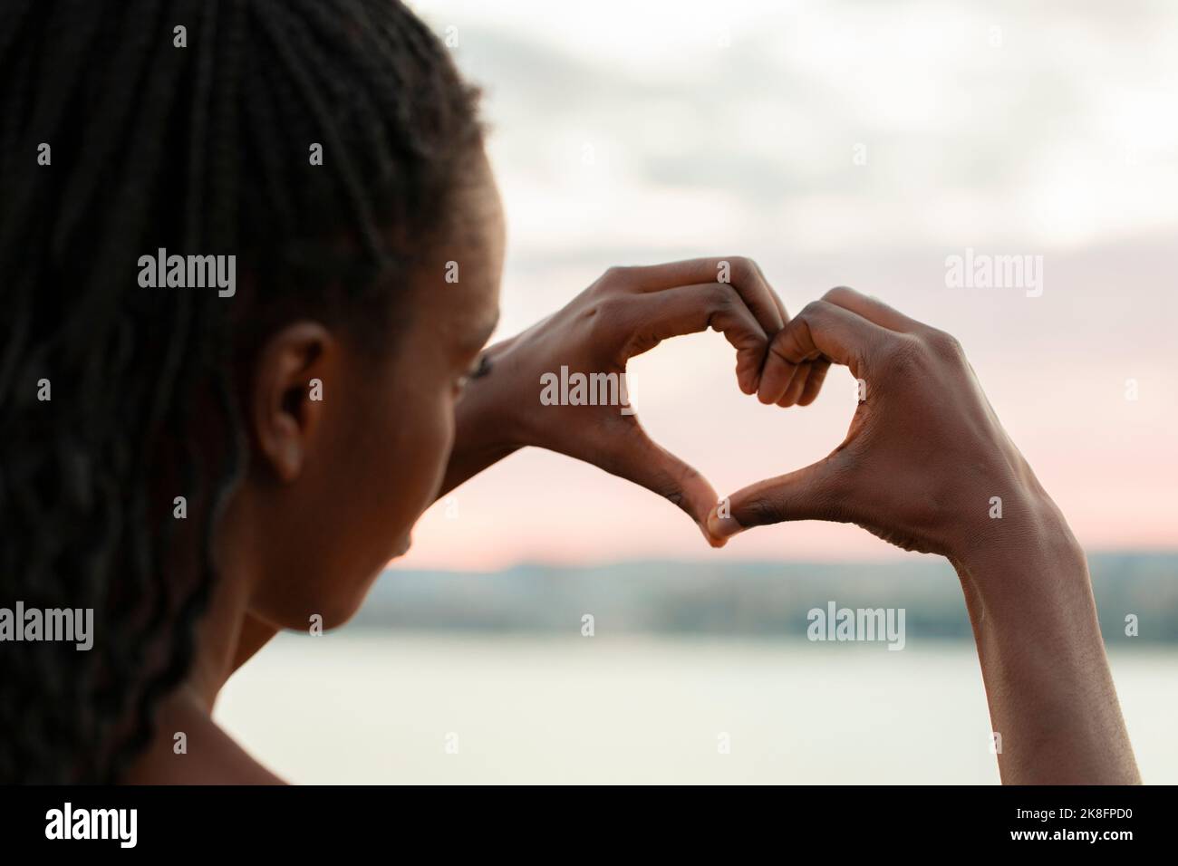 Woman making heart shape through hands Stock Photo - Alamy