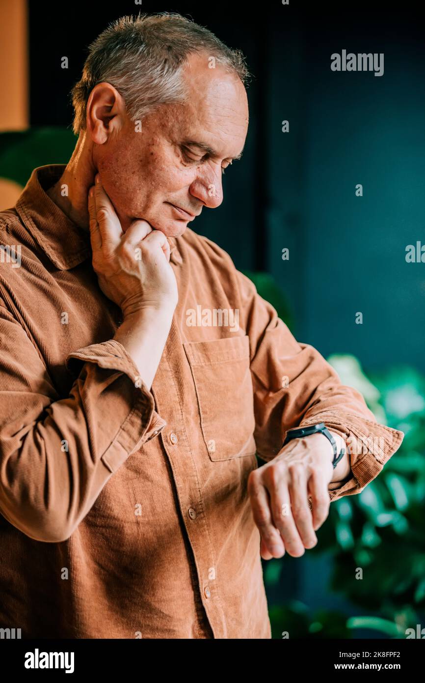 Senior man checking pulse on wristwatch Stock Photo - Alamy