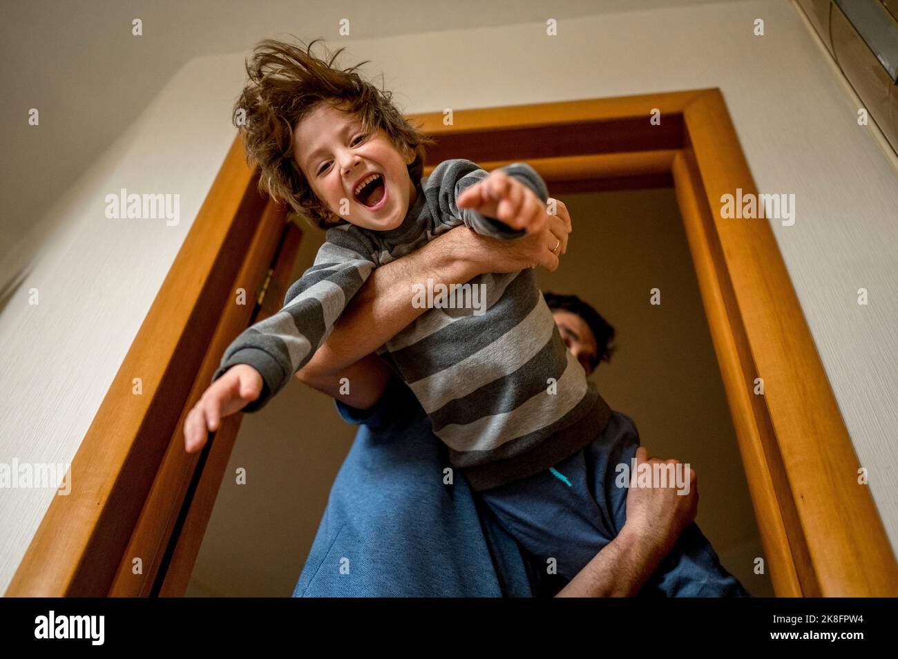 Playful father lifting son at home Stock Photo - Alamy
