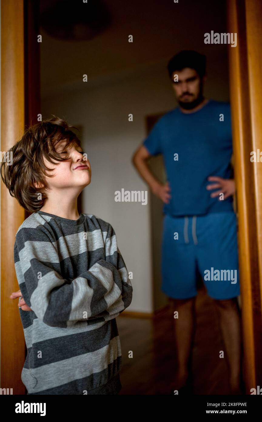 Father looking at angry boy at home Stock Photo - Alamy