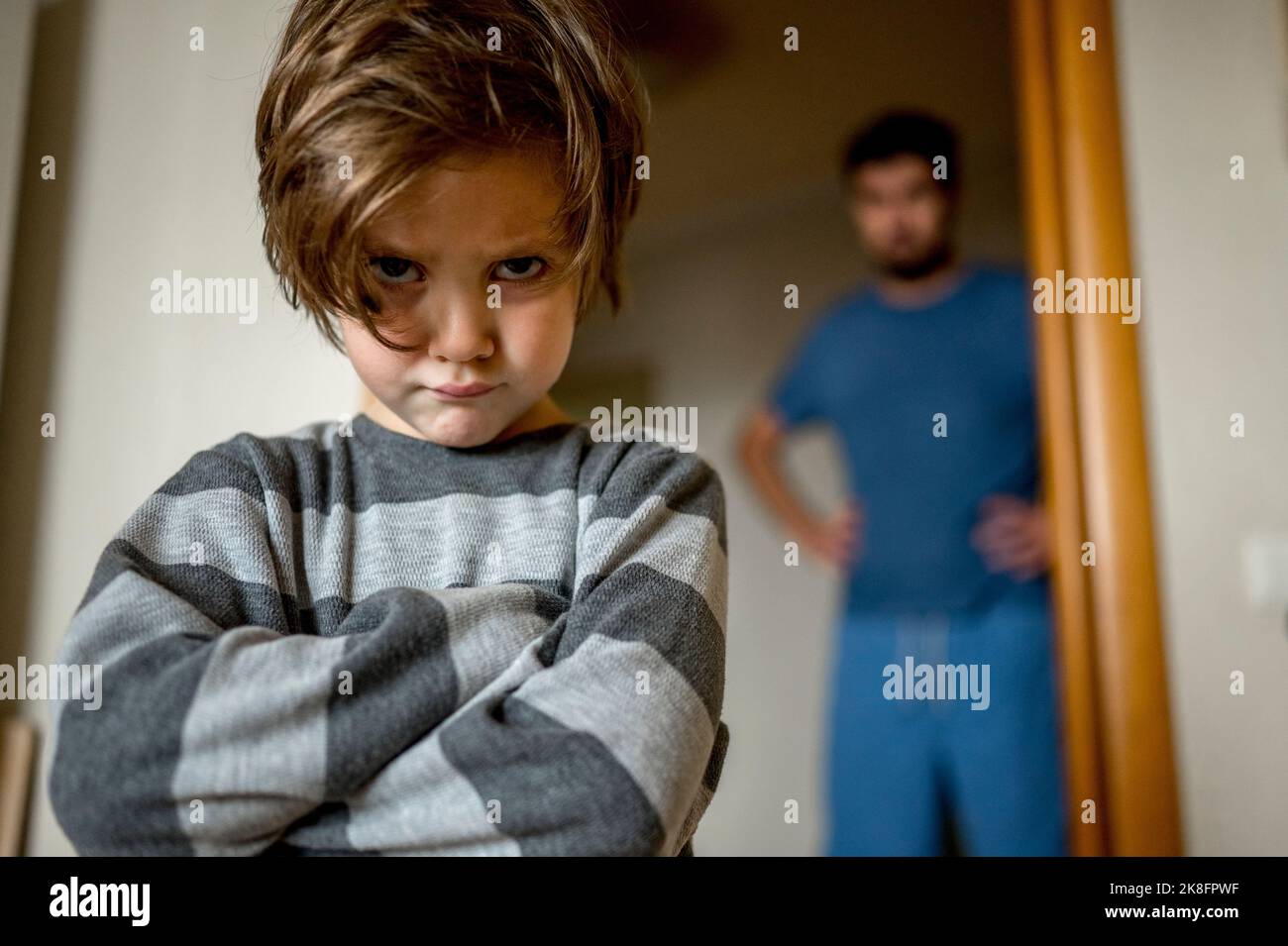 Father looking at angry son at home Stock Photo - Alamy