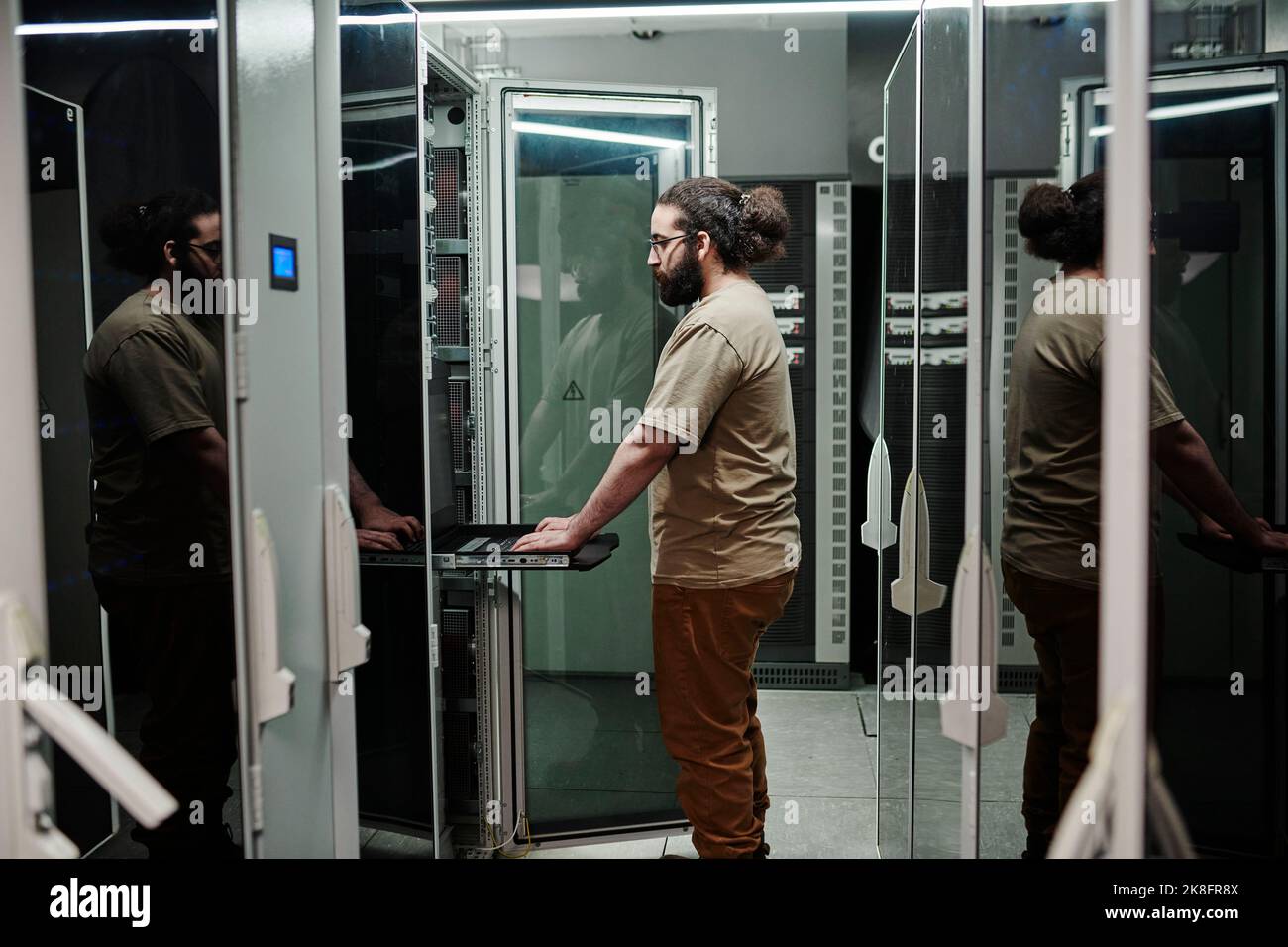 Computer technician working in server room Stock Photo - Alamy