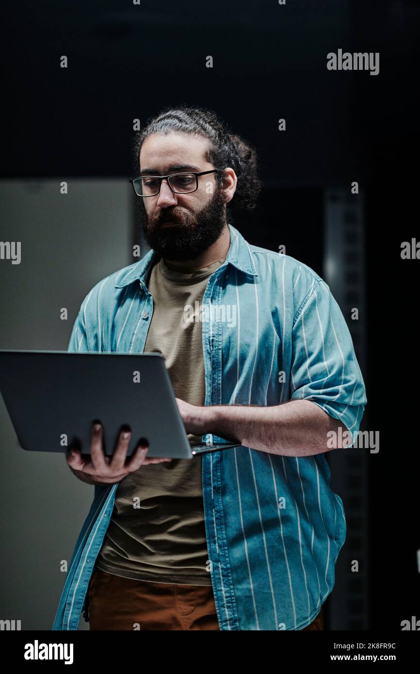 IT technician working on laptop standing in server room Stock Photo - Alamy