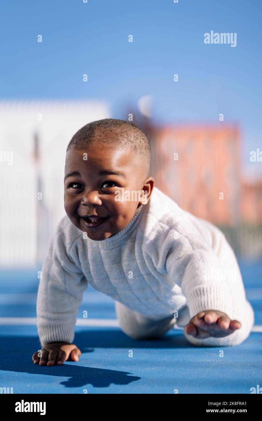Happy cute baby crawling on sports court Stock Photo - Alamy