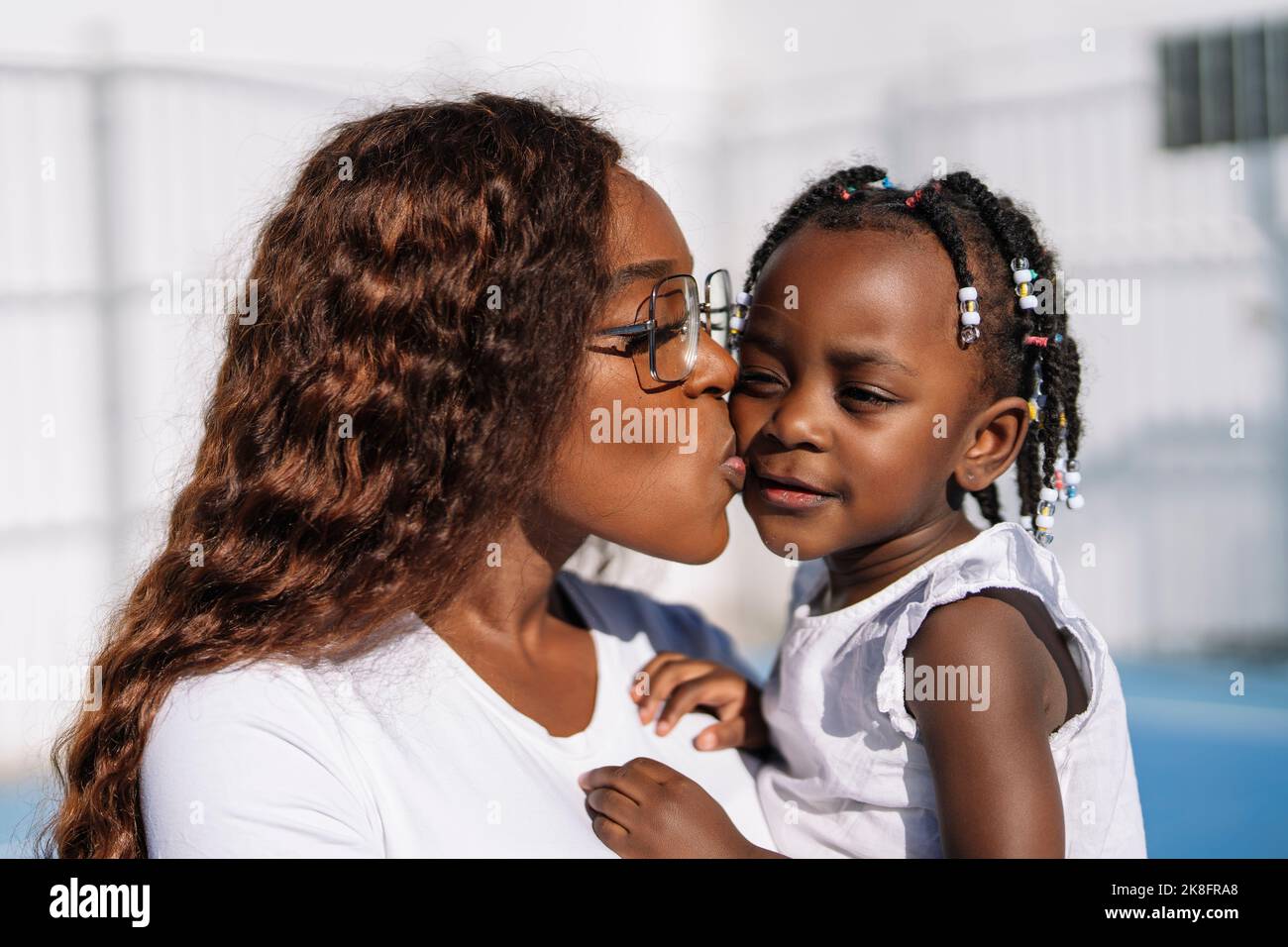 Woman kissing daughter hi-res stock photography and images - Alamy