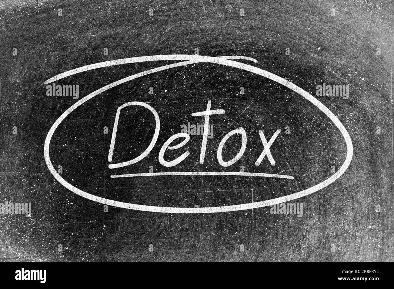 White chalk hand writing in word detox and circle shape on blackboard ...