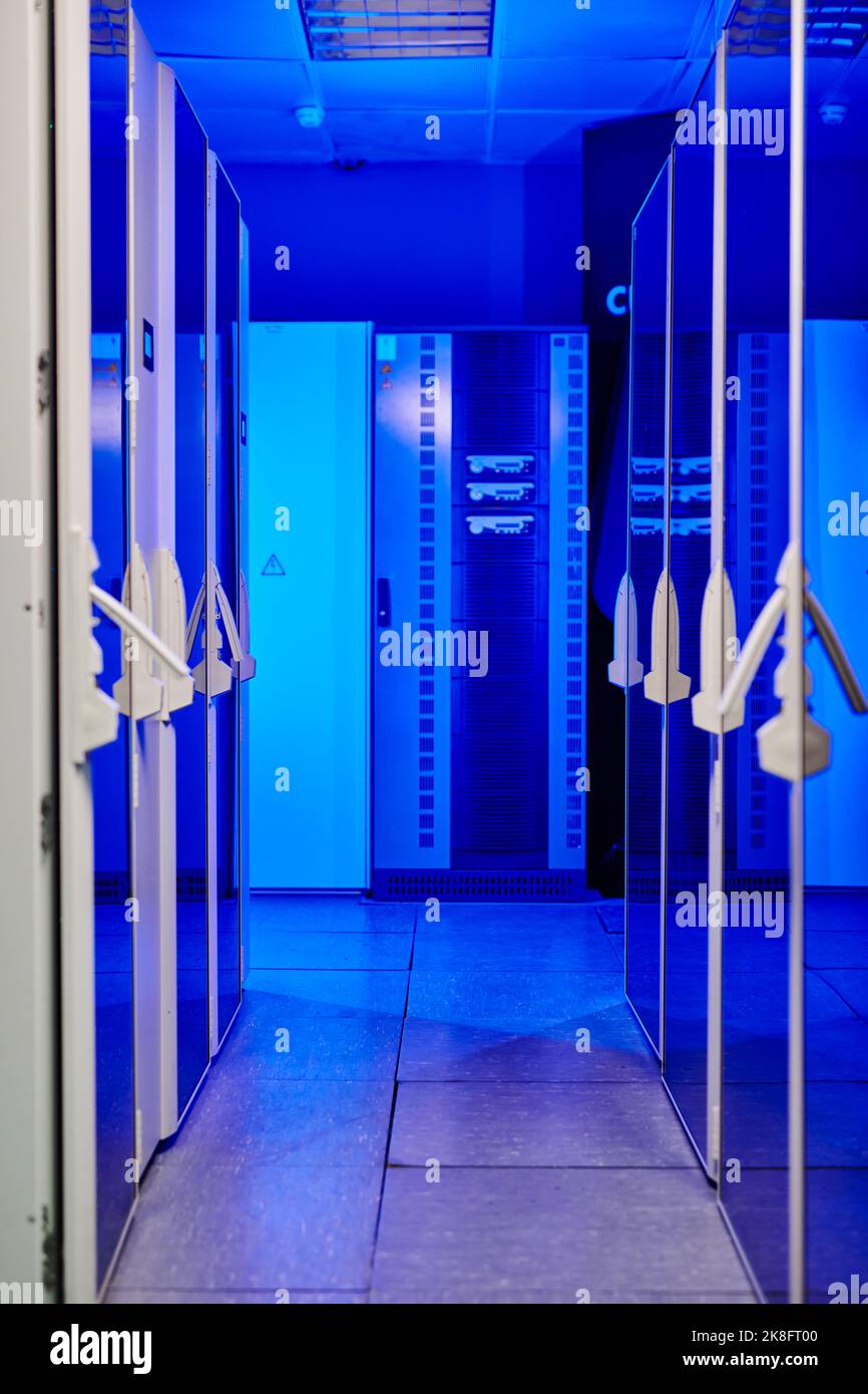 Corridor of illuminated server room with blue neon light Stock Photo ...