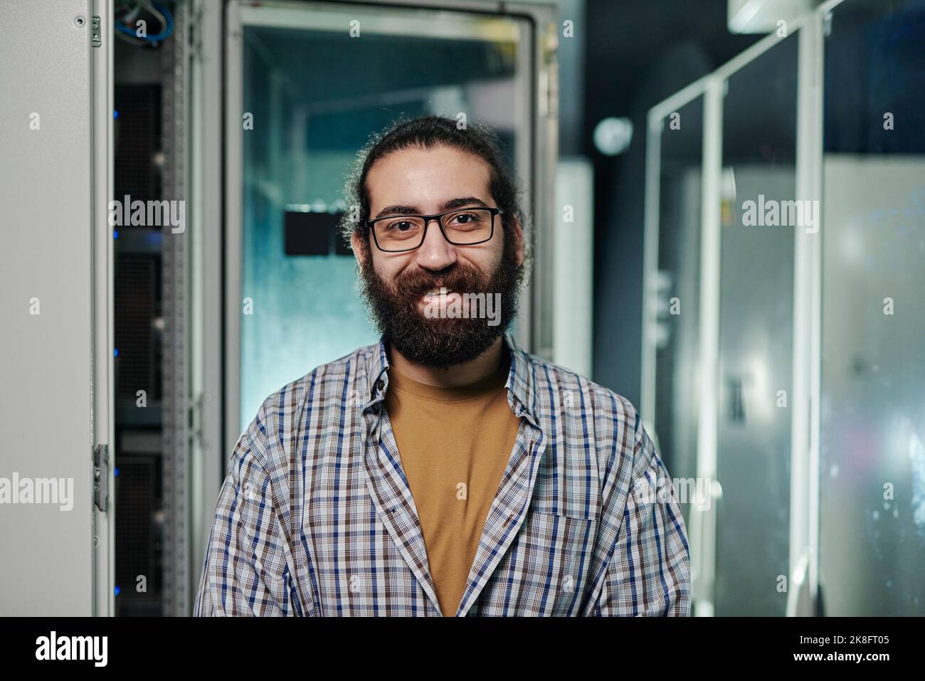 Happy computer programmer with beard wearing eyeglasses in server room Stock Photo - Alamy