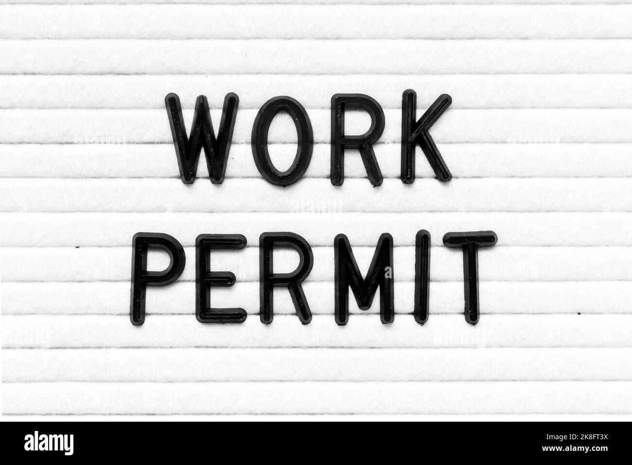 Black color letter in word work permit on white felt board background ...