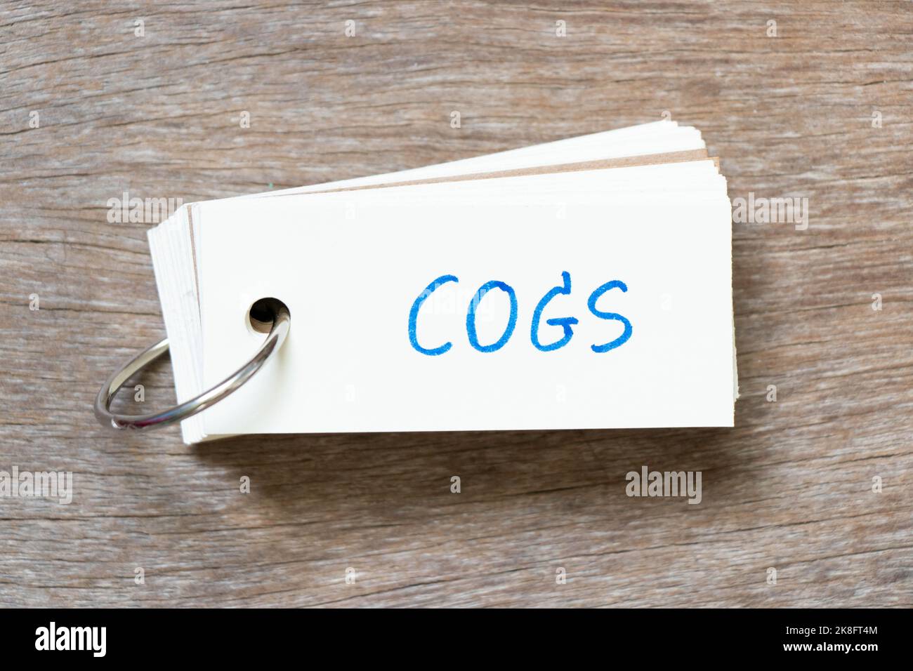 Flash card with handwriting in word COGS (Abbreviation of Cost of goods ...